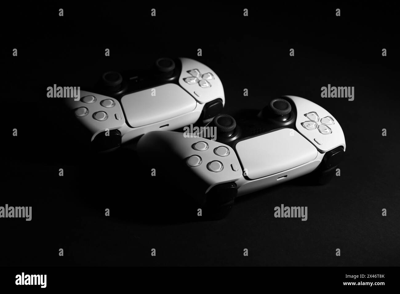 Two wireless game controllers on black background Stock Photo - Alamy