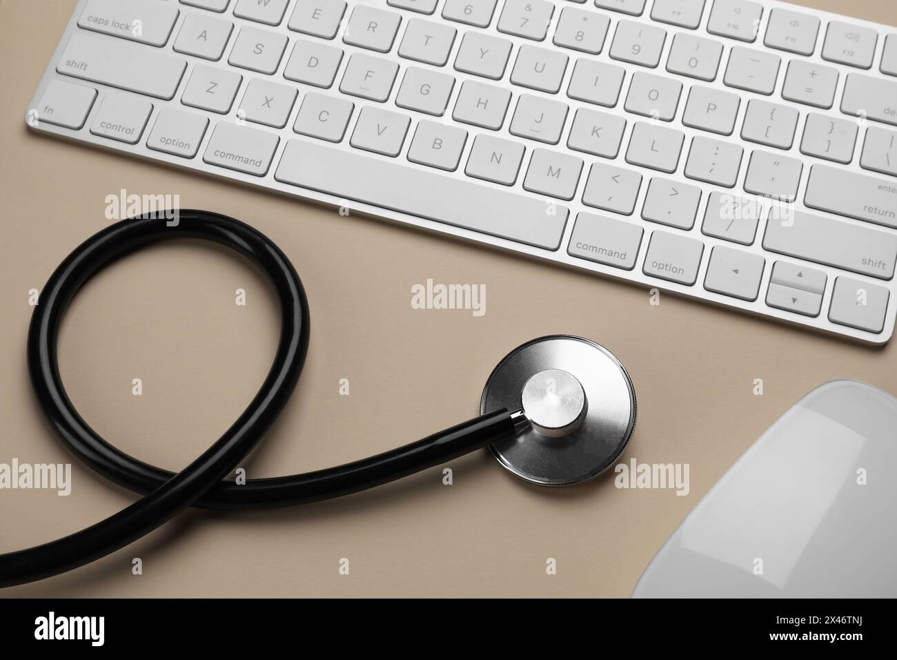 Medical stethoscope keyboard and computer mouse on beige background ...