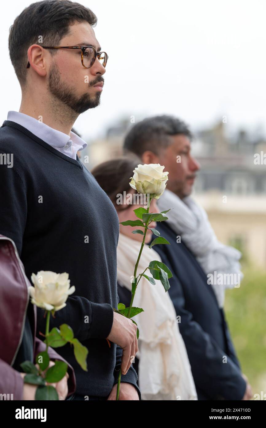 A family member holds a white rose to lay on the tomb of a fallen ...