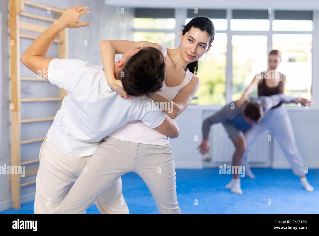 Young girl applying throwing technique on her opponent in sports hall ...