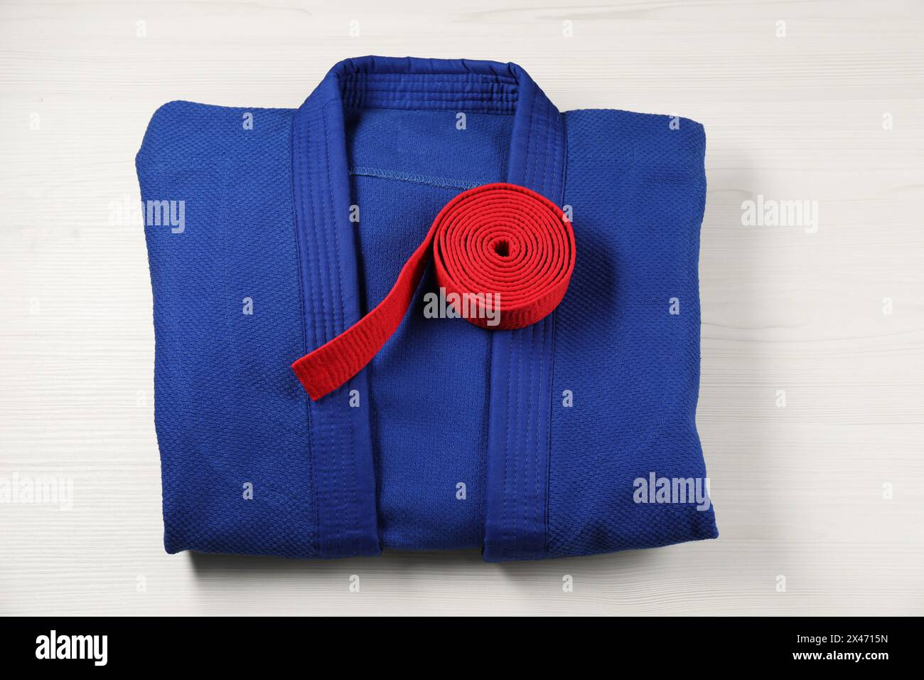 Red karate belt and blue kimono on wooden background, top view Stock ...