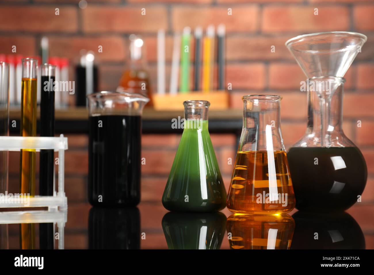 Laboratory glassware with different types of oil on mirror table ...