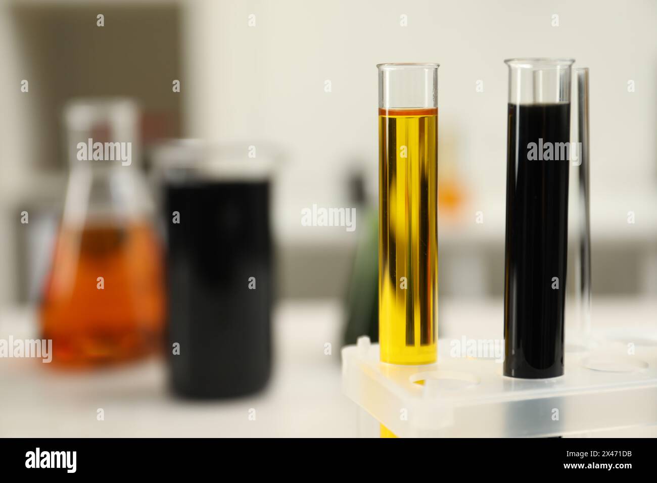 Test tubes with different types of crude oil against blurred background ...