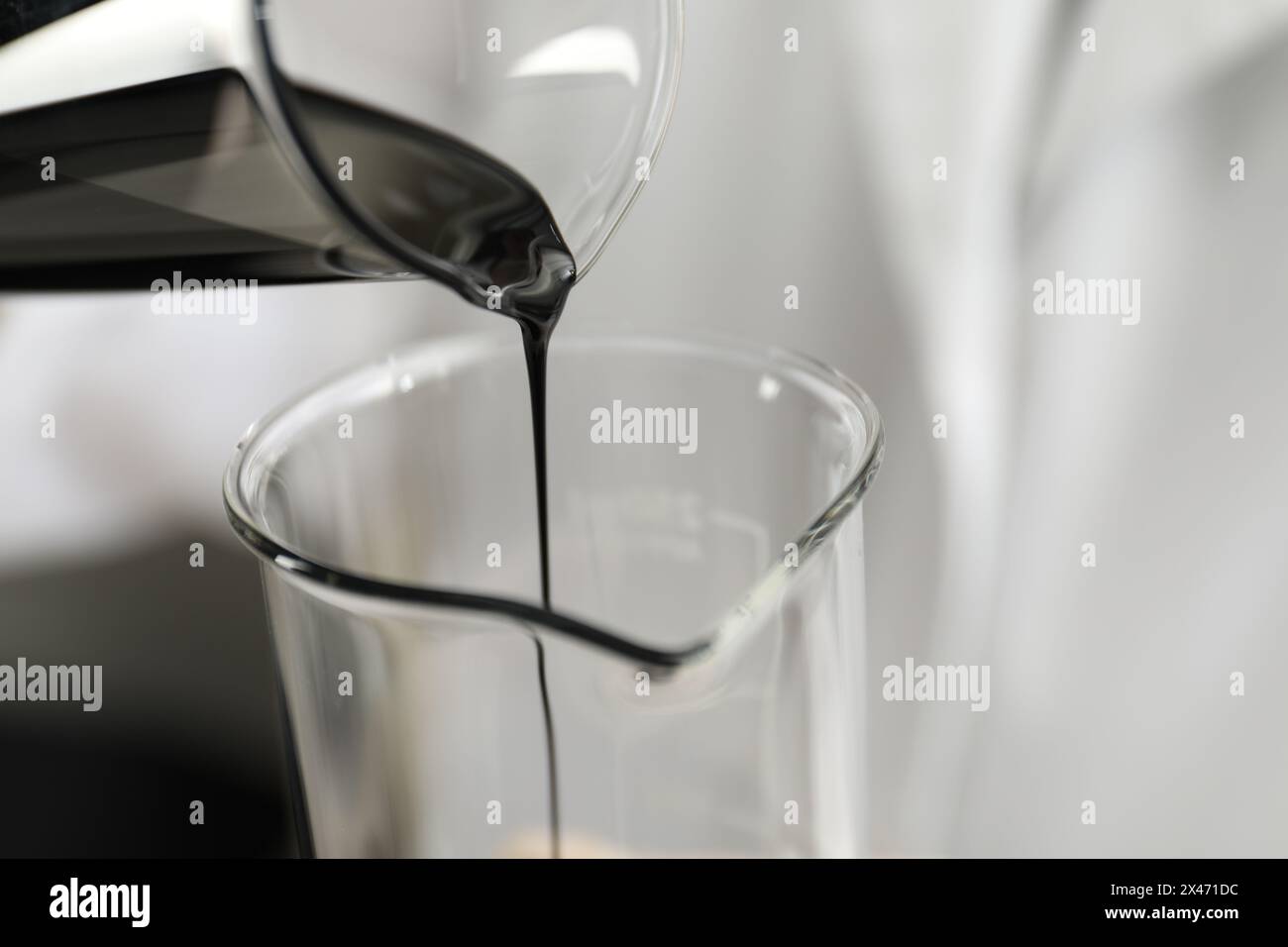 Pouring crude oil into beaker against blurred background, closeup Stock ...