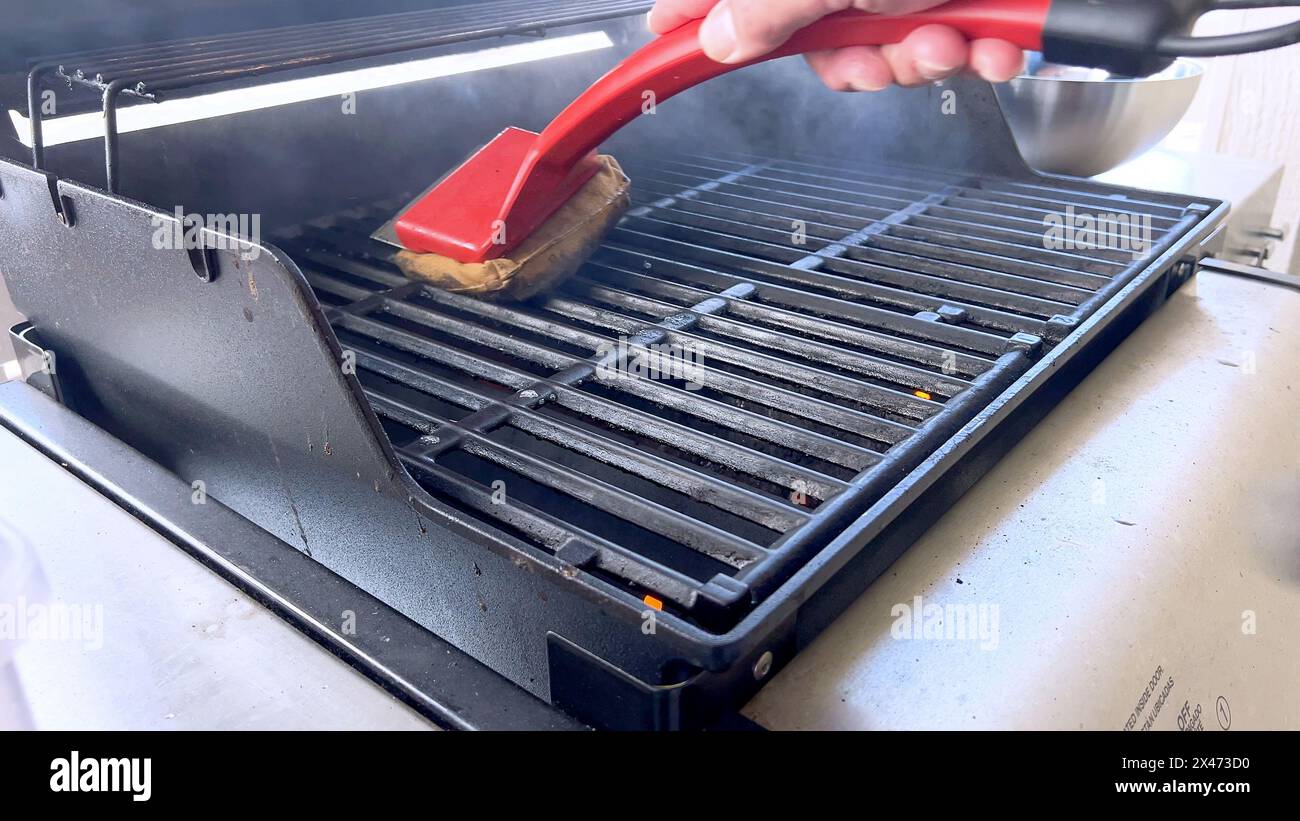 Cleaning a Barbecue Grill with a Brush After Cooking Stock Photo - Alamy