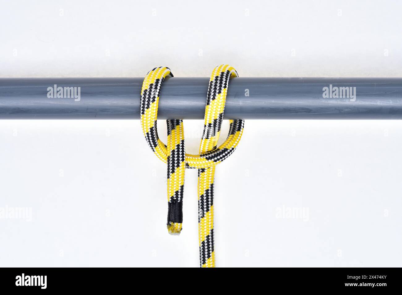 Clove hitch knot on yellow and black nylon rope on white background ...