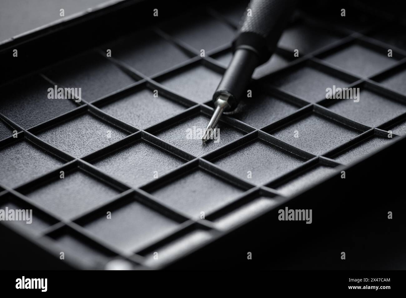 Torx drive bit and aluminum bit driver on black sorting tray ...