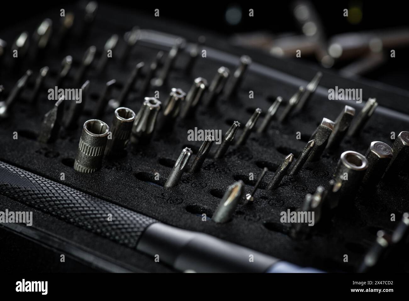 Screwdriver kit with aluminum bit driver on black tray. Driver handle ...