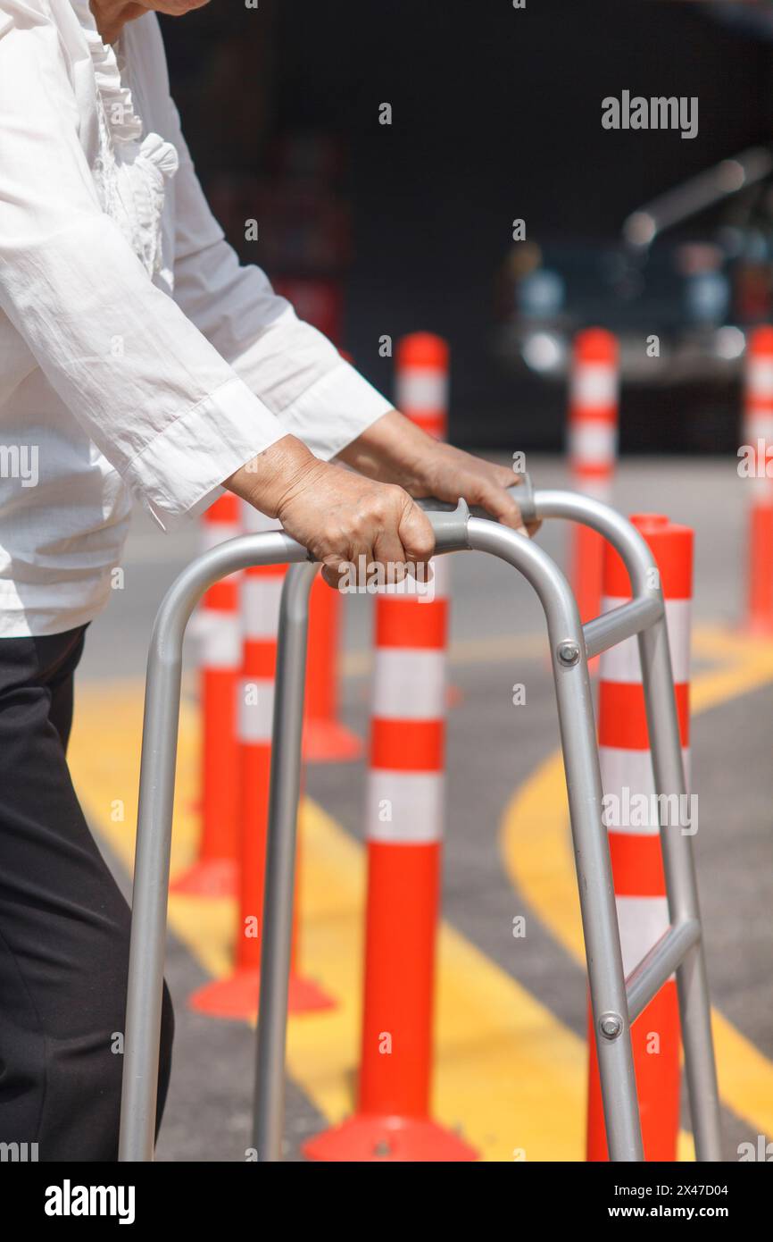 Senior woman using a walker cross street Stock Photo - Alamy