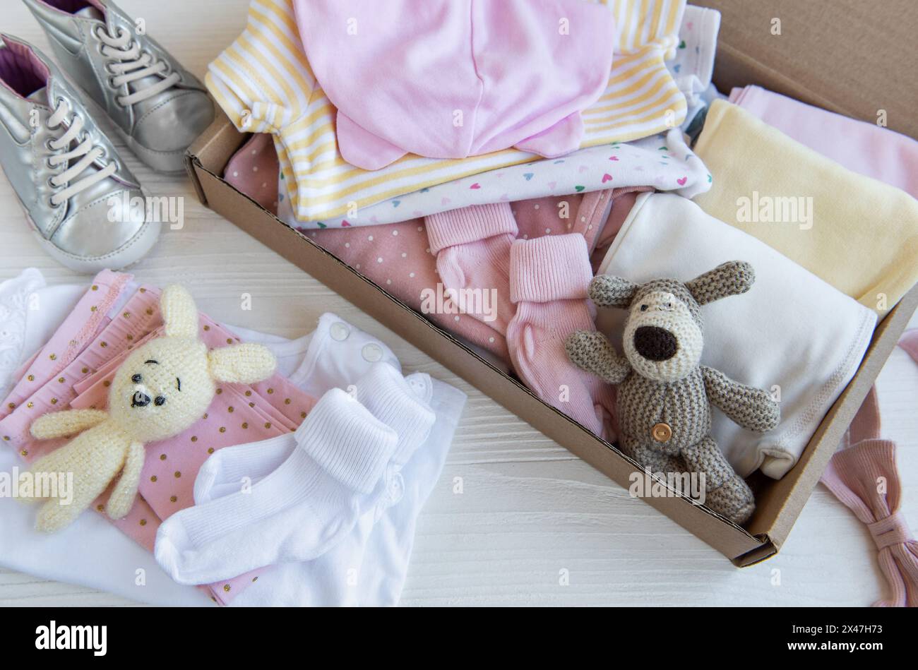 Baby and child clothes and knitted toys in carton box. Donation ...