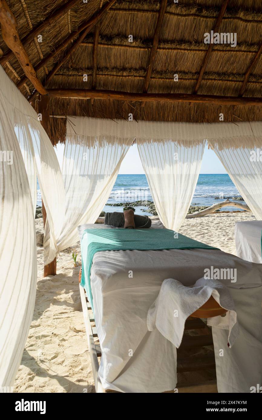 Caribbean beachfront cabana spa with empty massage table, offering ...