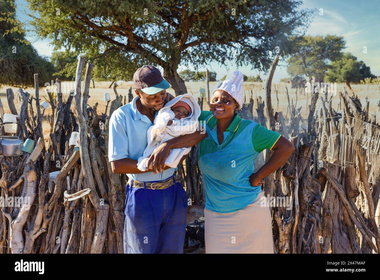 african village, family, mom , father and small baby, standing in front ...