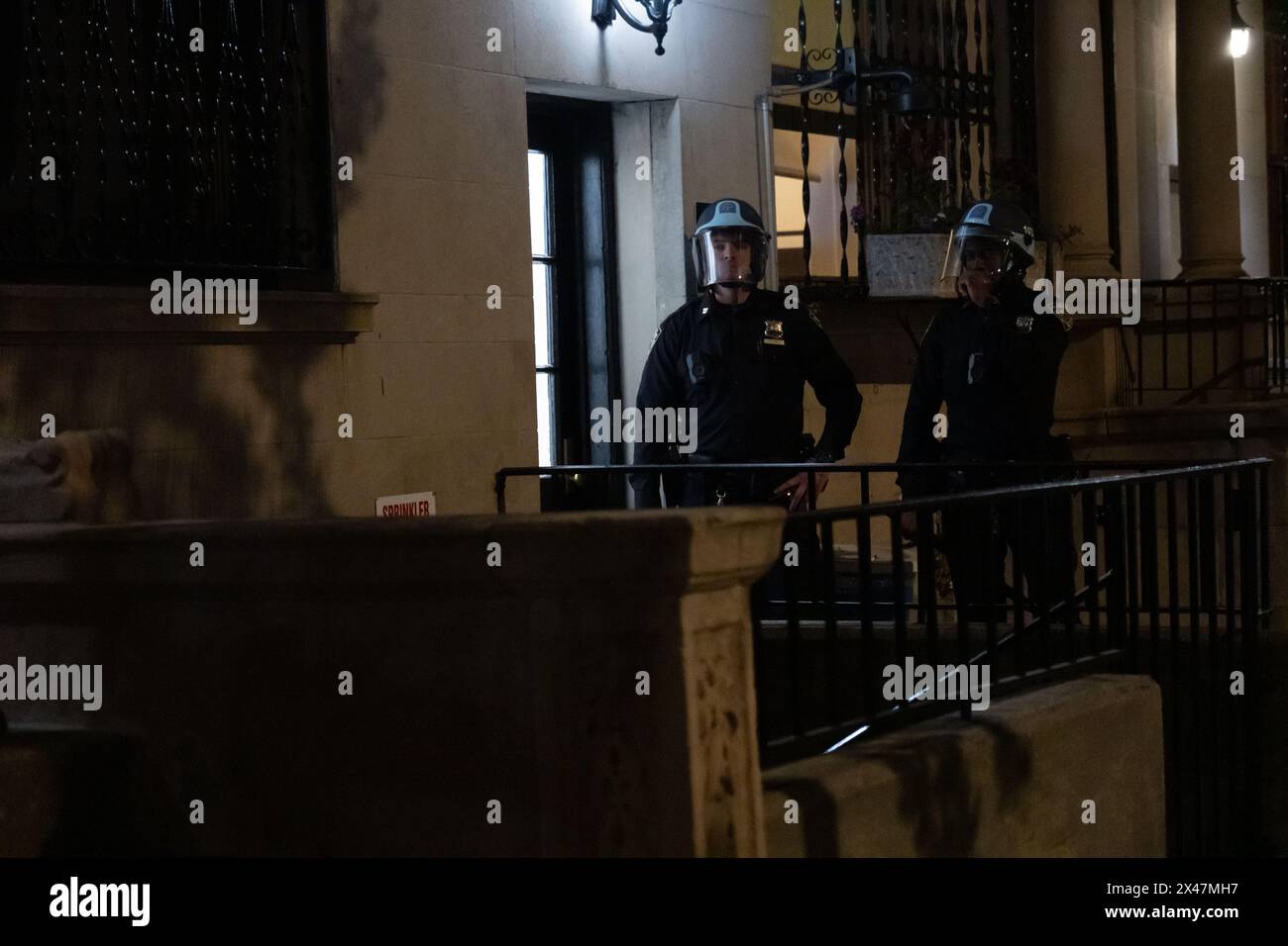 Two NYPD officers stand guard by an apartment building. Ordered to not ...