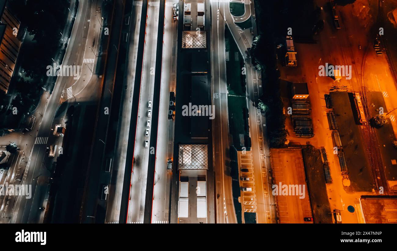 Aerial view of the bus station and road traffic at night. White taxi ...