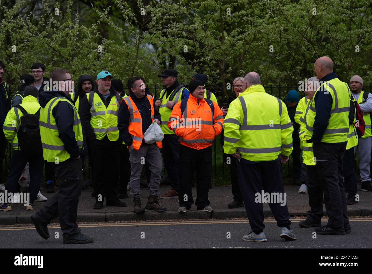 Members of staff wait across the road as protesters form a blockade ...