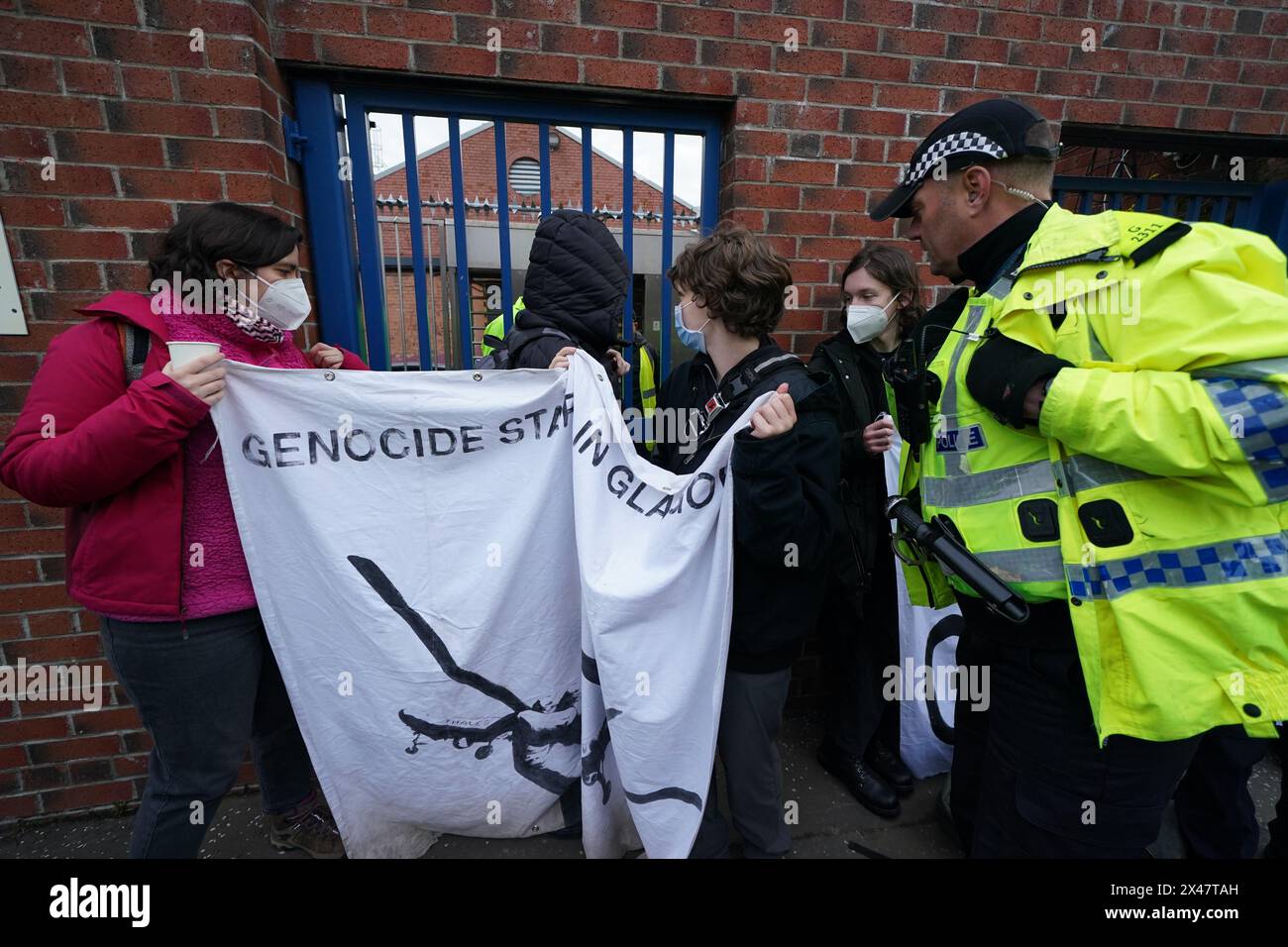 A police officer speaks with protesters forming a blockade outside ...