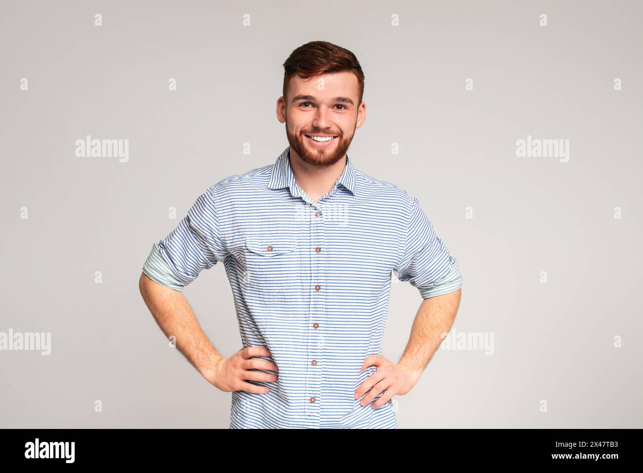 Portrait of smiling guy with hands on hips Stock Photo - Alamy