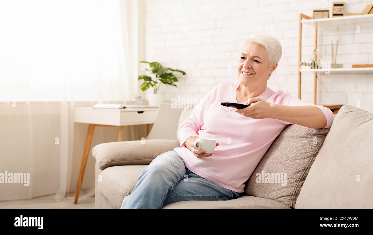 Elderly Woman Sitting on Couch Holding Remote Control Stock Photo - Alamy