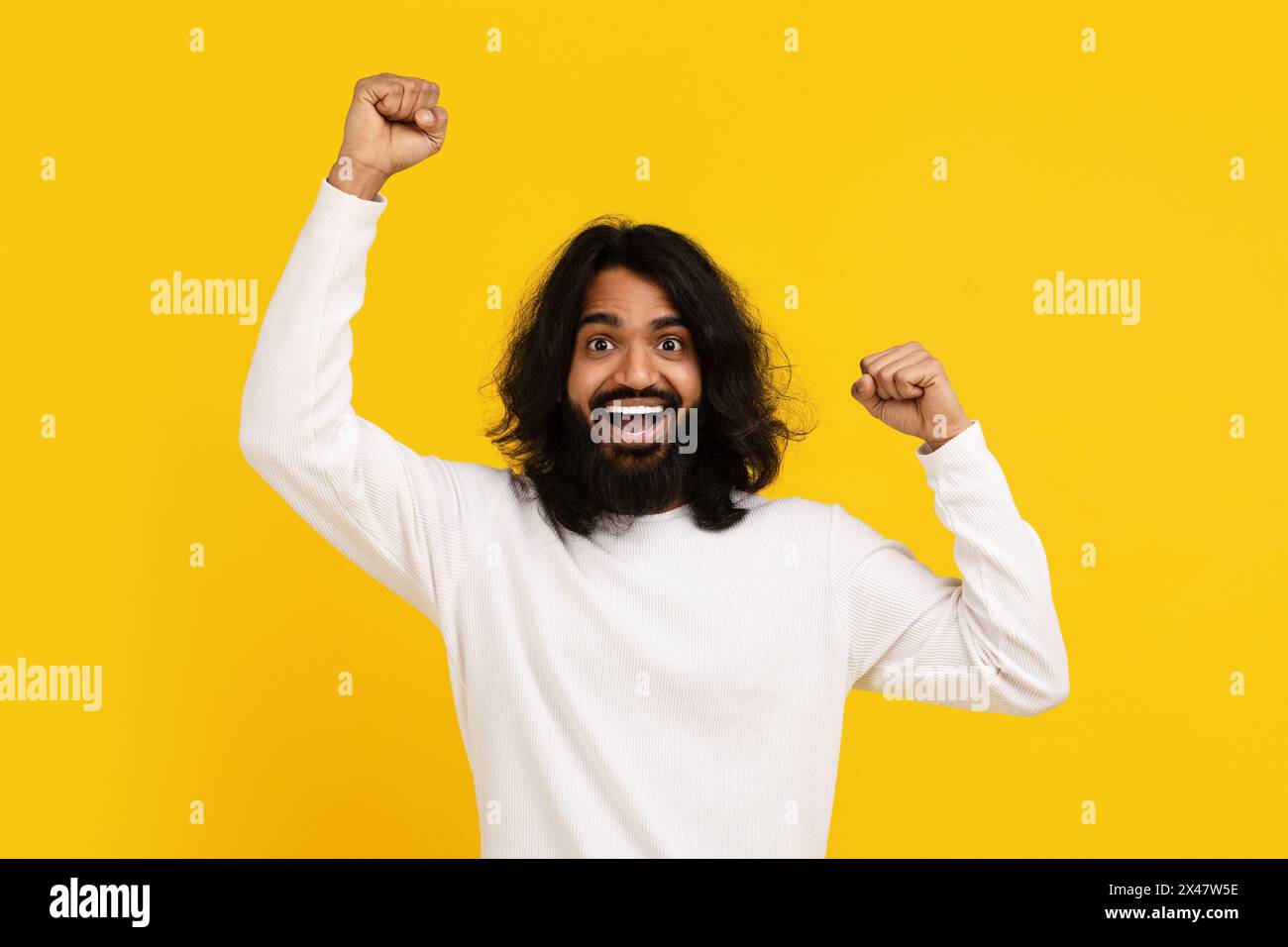 Jubilant Young Man Celebrating Success With Raised Fists Stock Photo ...