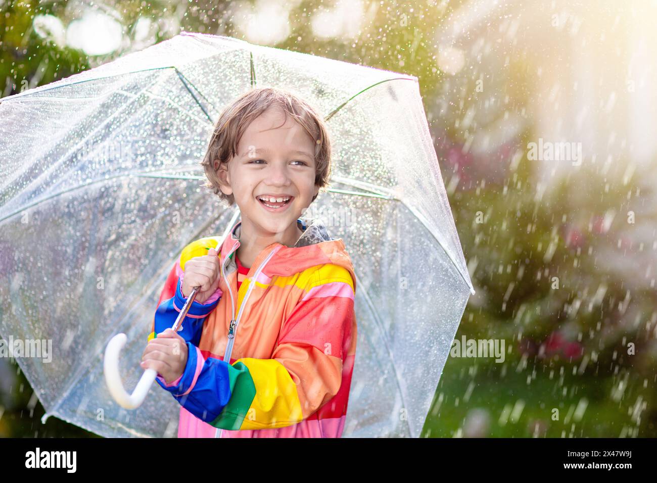 Child playing in autumn rain. Kid with umbrella. Little boy running in ...