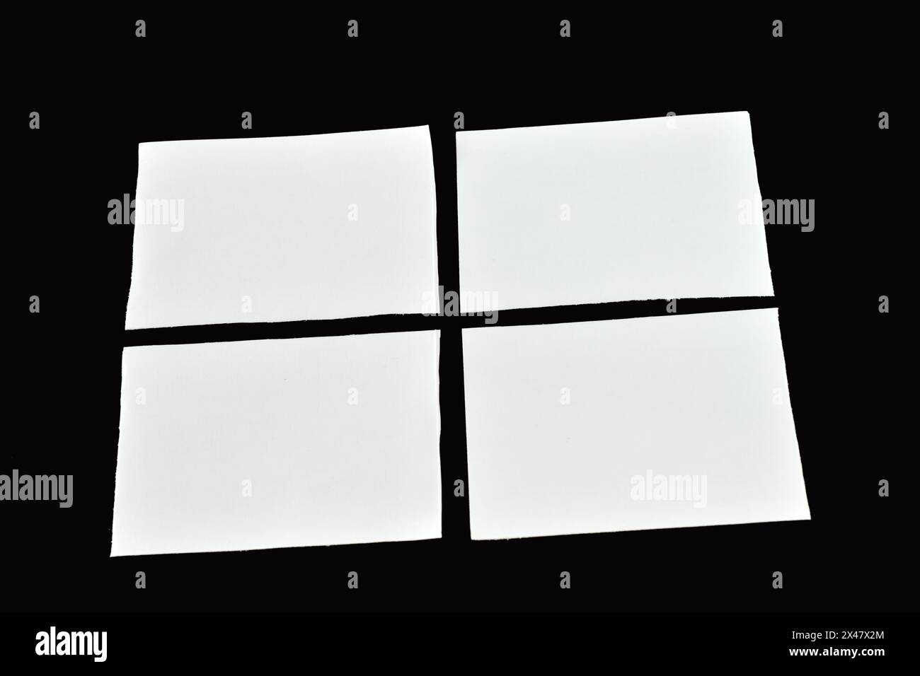 On a black background there are four clean white paper sheets with ...