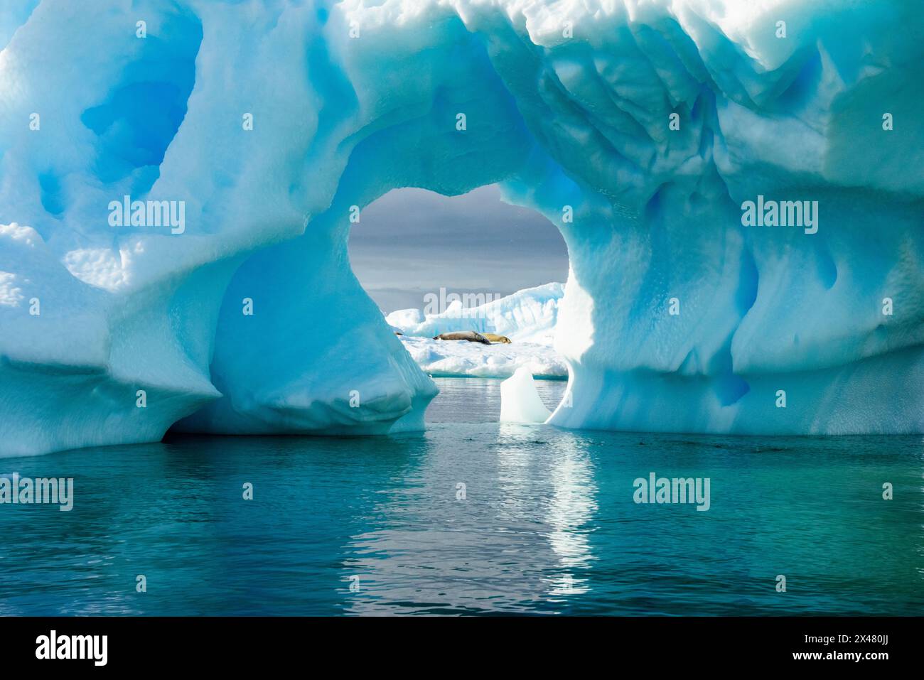 French Passage, Antarctica. Looking through a hole in an iceberg in the ...