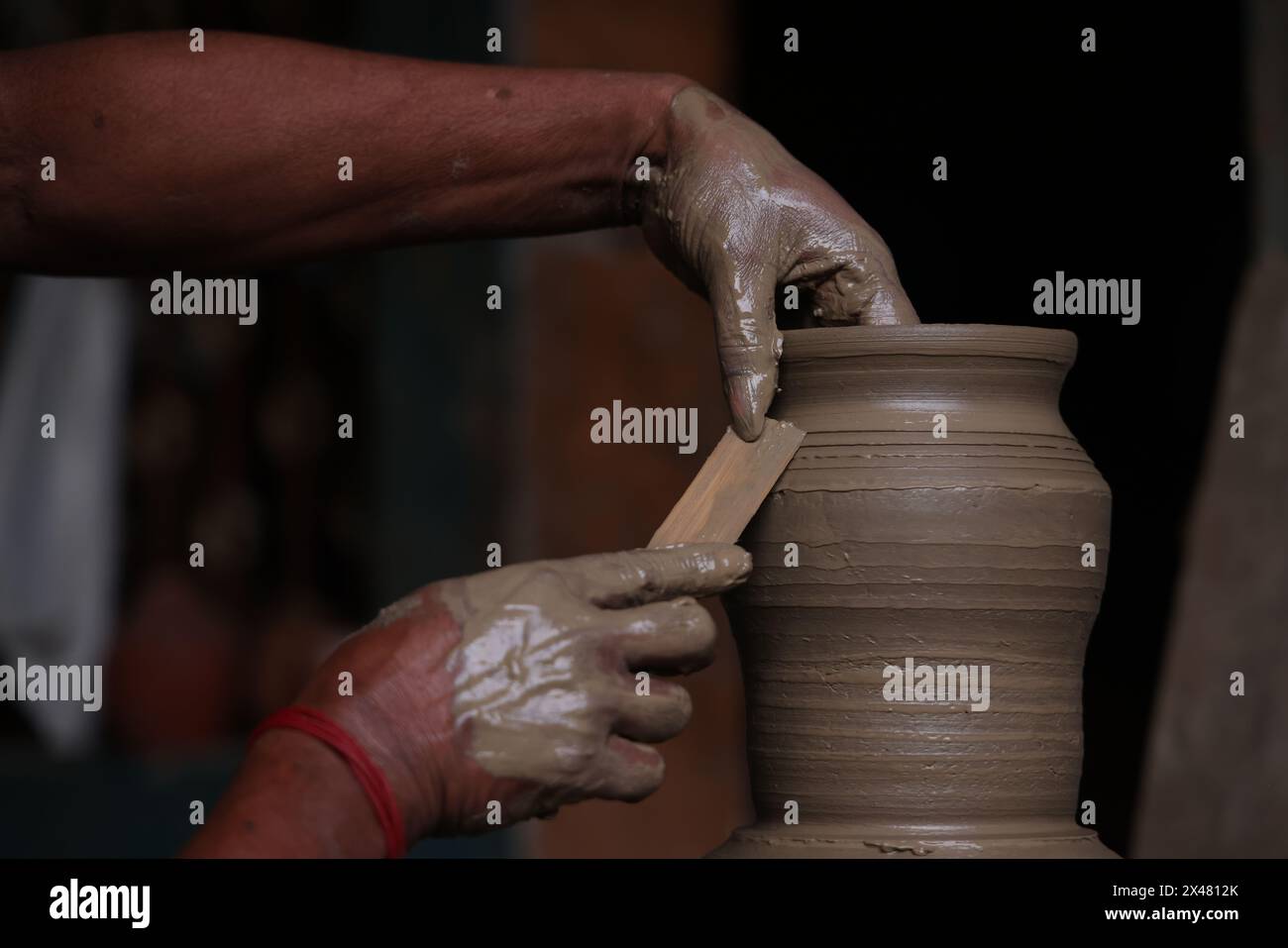The potter works on a pottery wheel to made of soft colored clay, retro ...