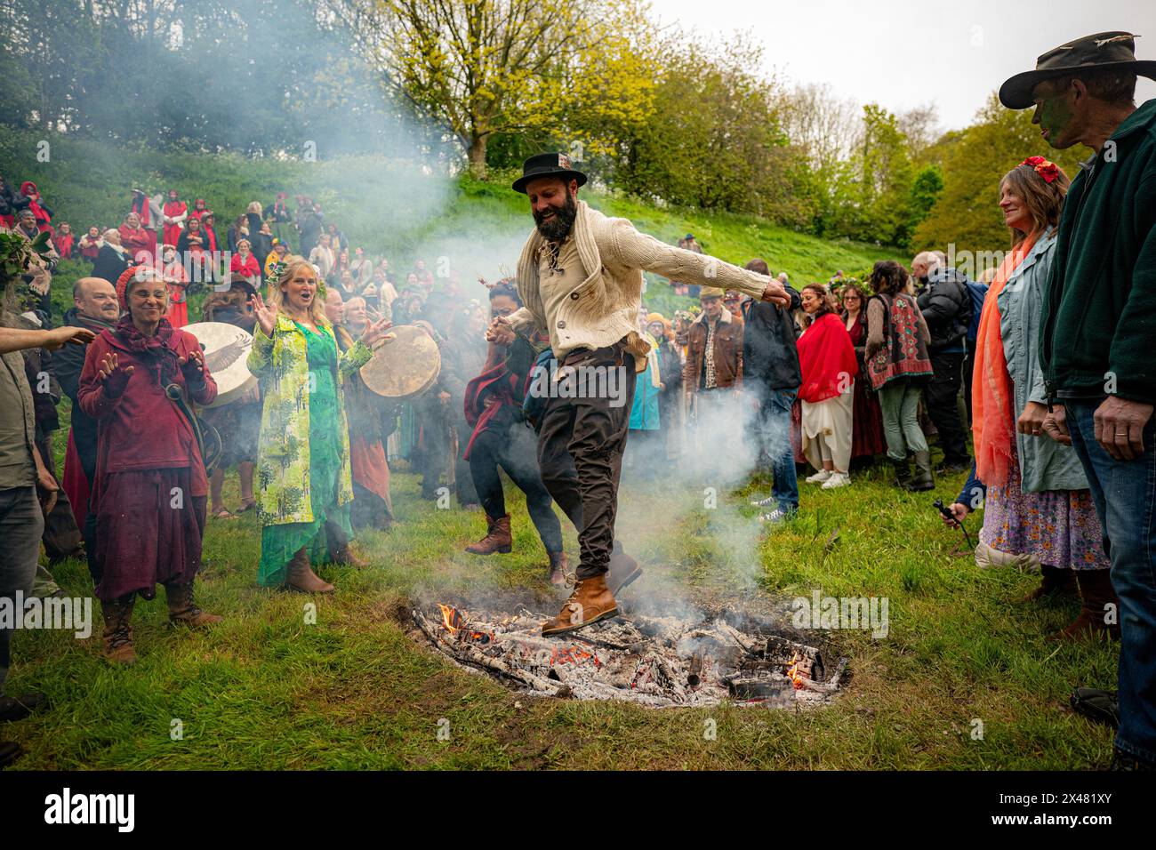 People jump the fire during the Beltane celebrations at Glastonbury ...