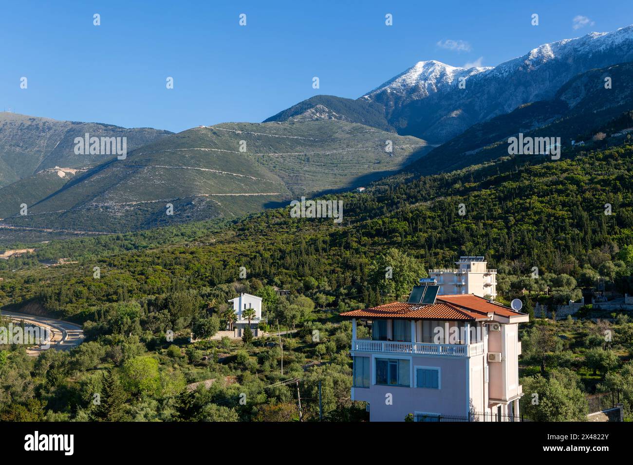 Snow capped peak of Mount Cika and mountain road over Llogara Pass ...