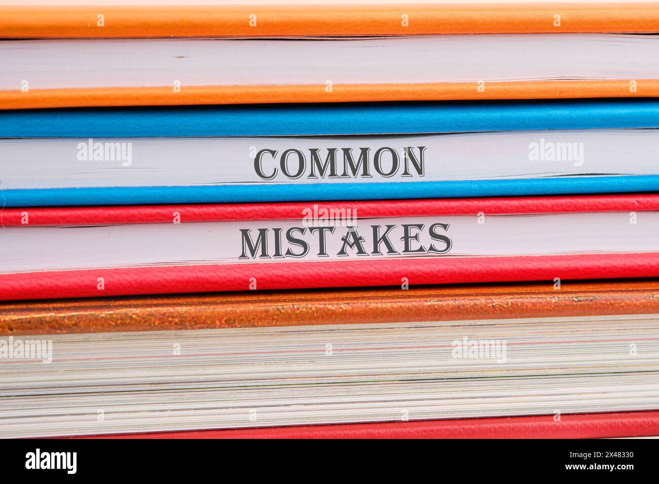 Common mistakes, text on notebooks stacked in a pile Stock Photo - Alamy