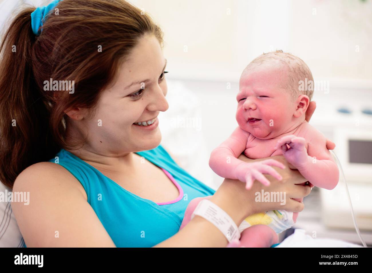 Mother giving birth to a baby. Newborn baby in delivery room. Mom ...