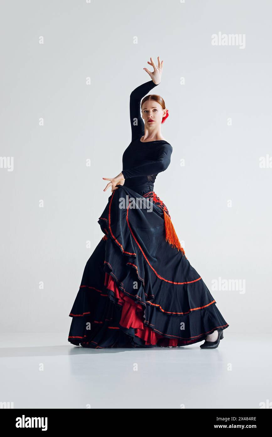 Dynamic portrait of female flamenco dancer in artistic dress dancing ...