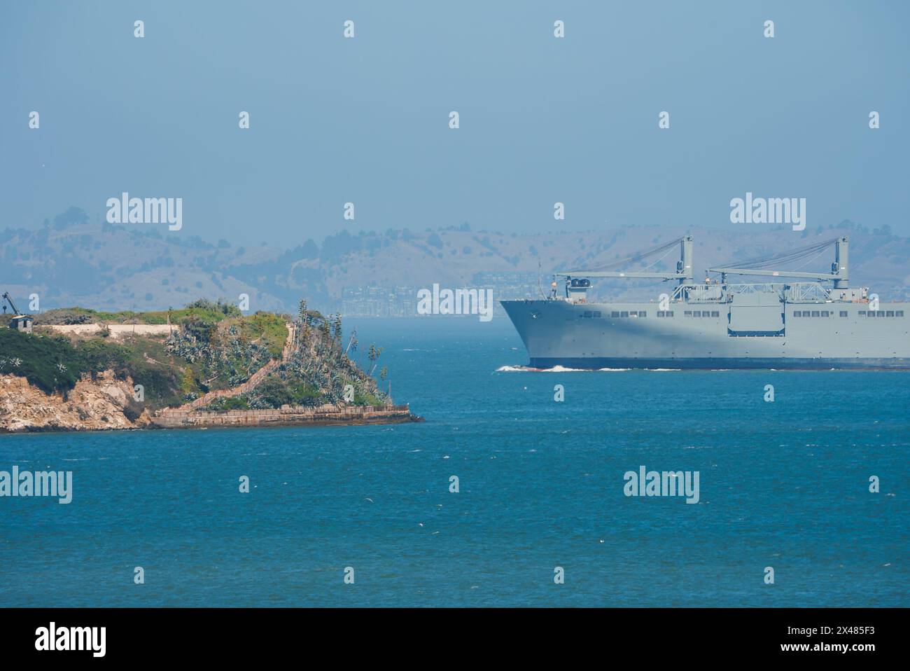 Maritime scene with large ship sailing through San Francisco Bay, rocky ...