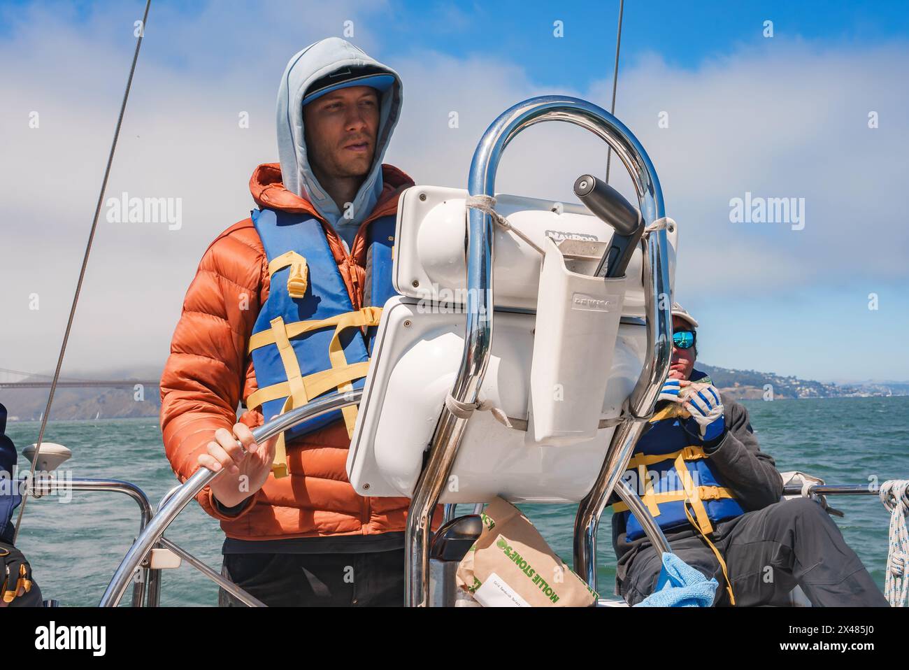 Boat captain in red jacket guides ship near San Francisco Coast Stock ...