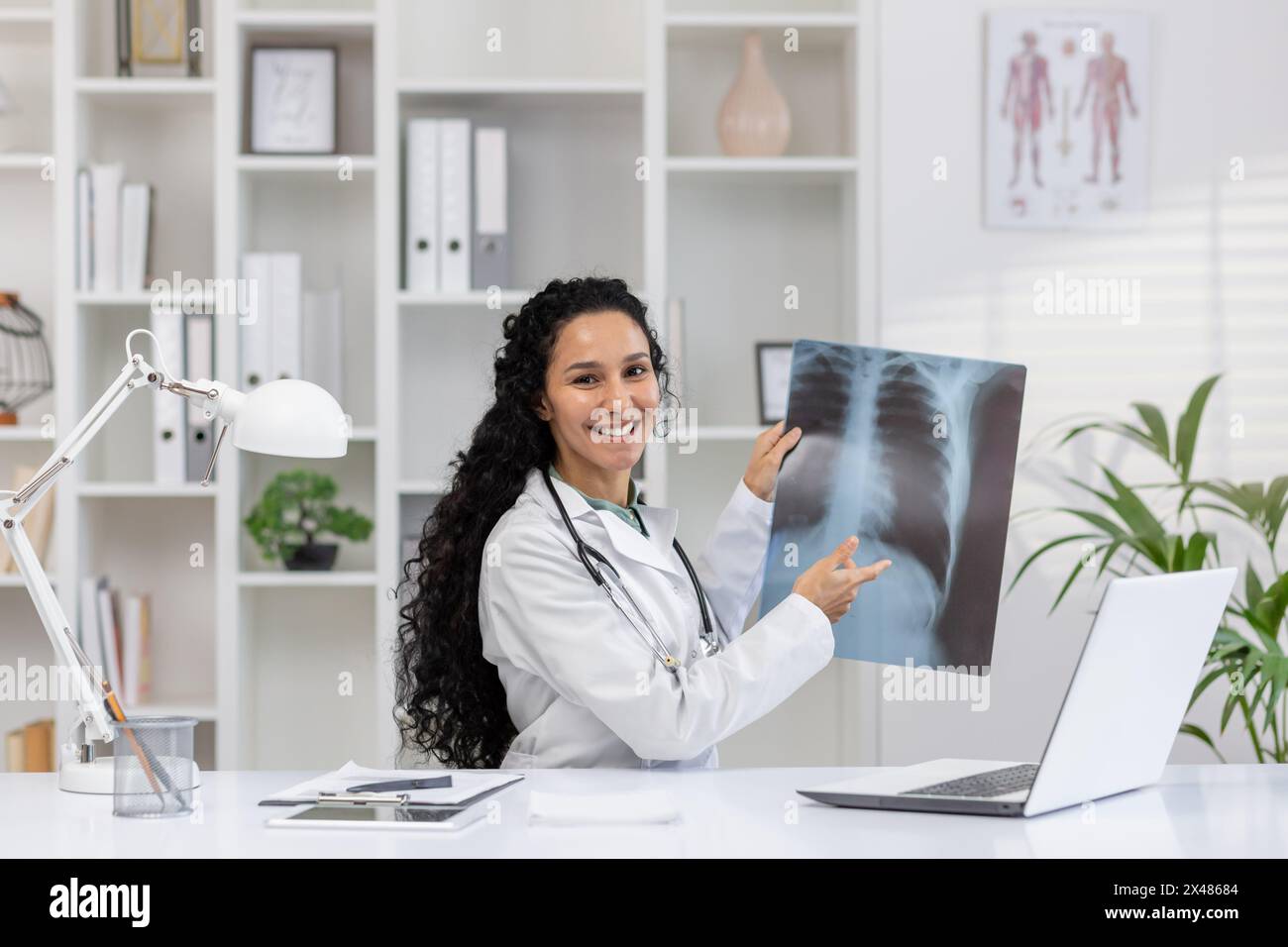 A professional female radiologist in a white lab coat is joyfully ...