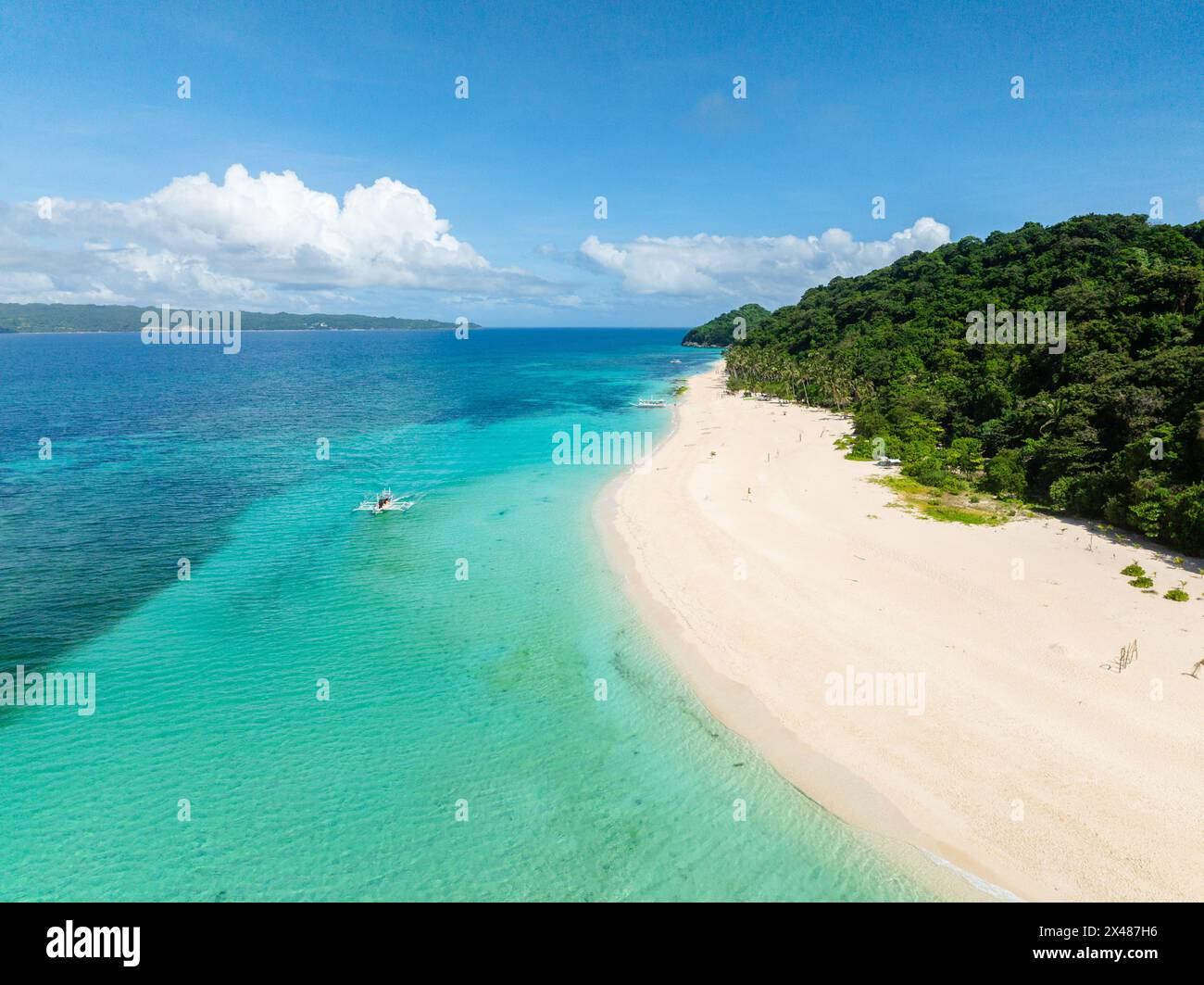 Boat over clear water in Puka Shell Beach with white sand. Boracay ...