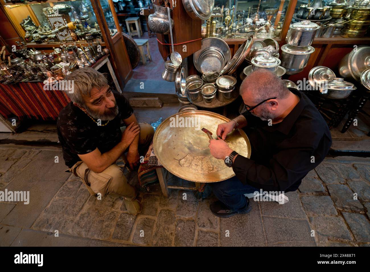 Coppersmith at work engraving a copper plate, Gaziantep bazaar, Turkey ...