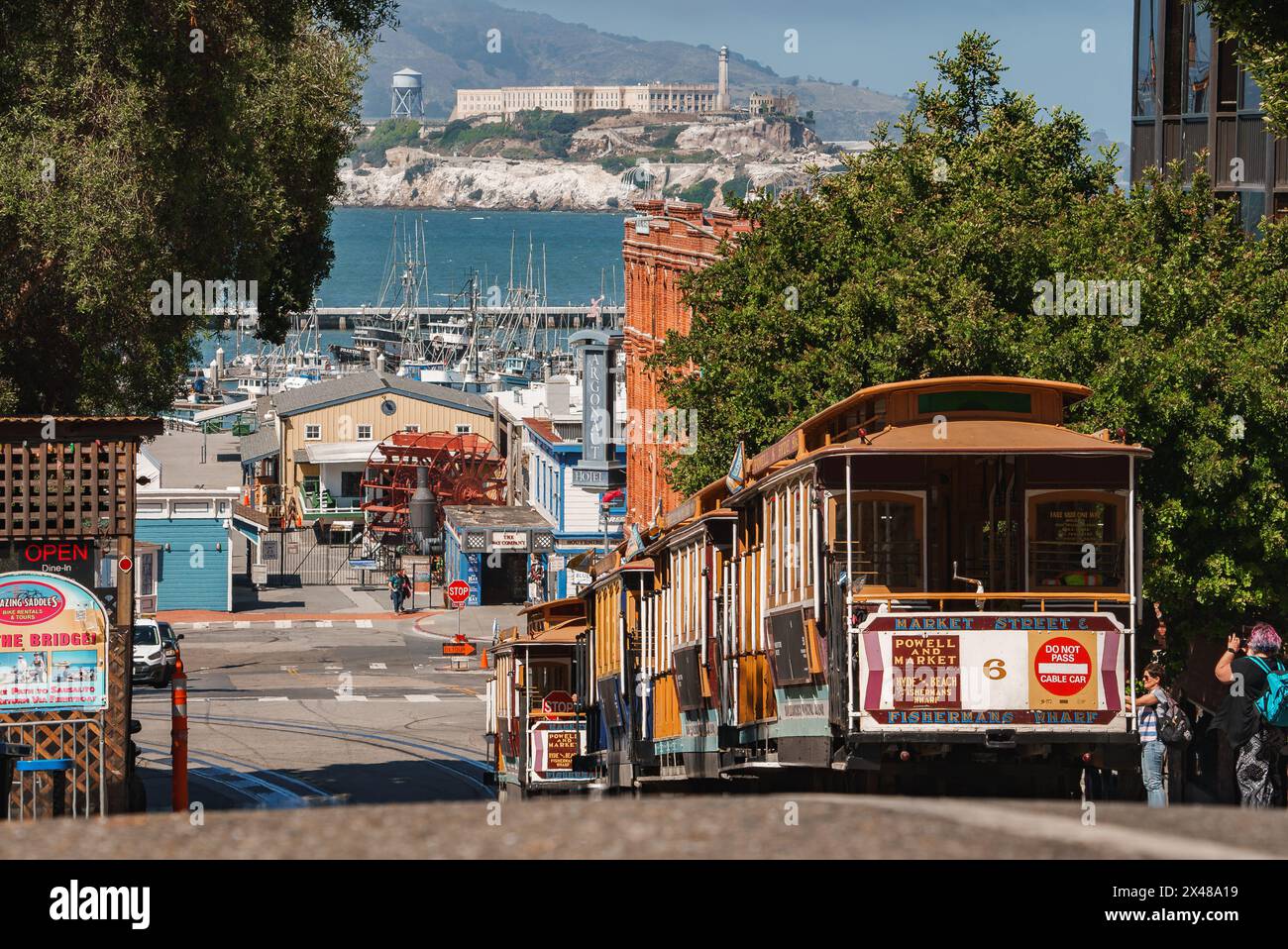 Iconic San Francisco cable car on sloping street with marina, Alcatraz ...