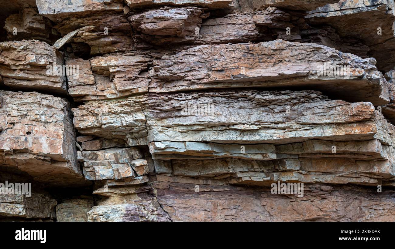A rocky cliff with a brown and red color. The rocks are piled up and ...