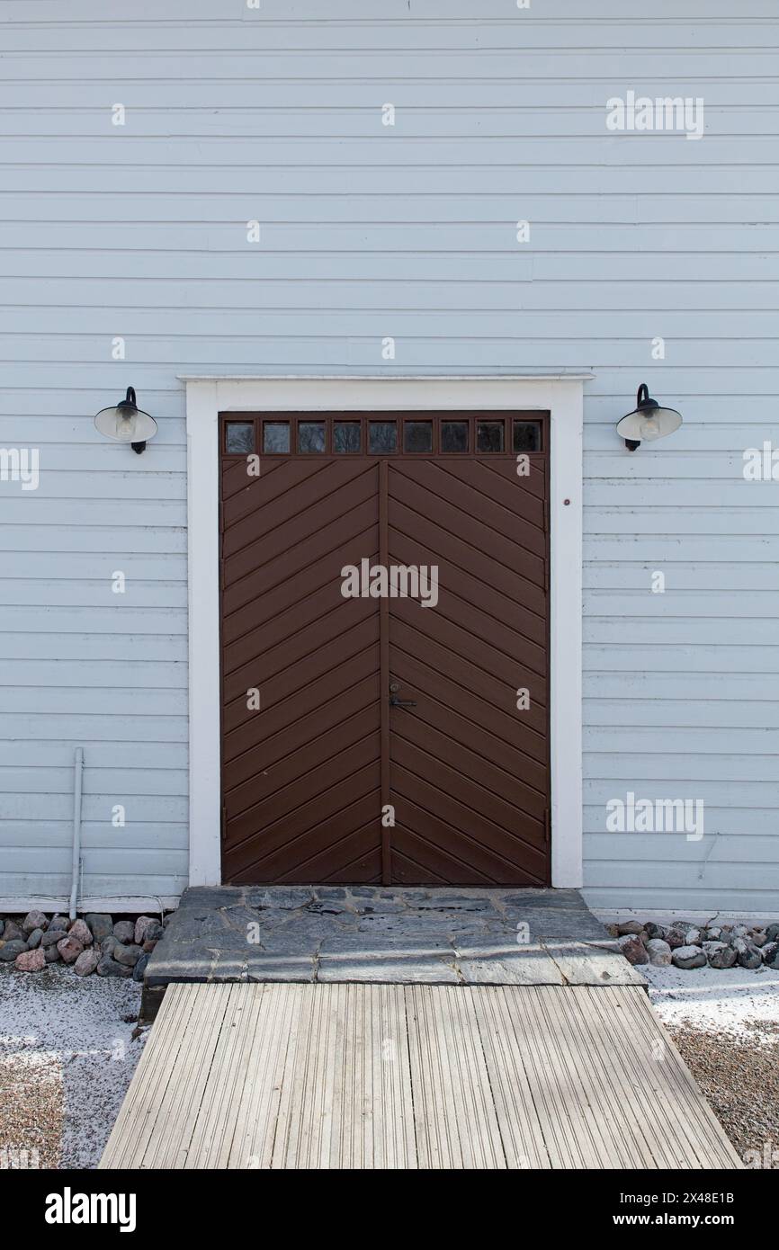 Closed old brown double doors with white frame and light blue board ...