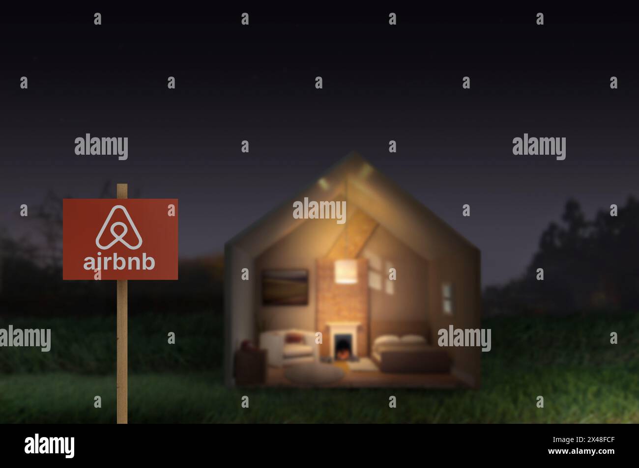 Airbnb sign next to a model house in the evening with lights on inside ...