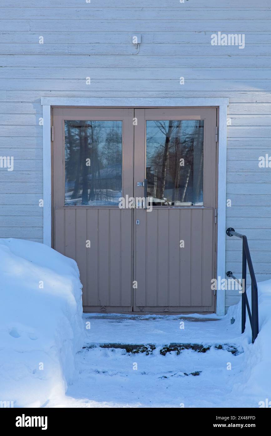 Double doors and steps on a old wood building in winter with snow on ...