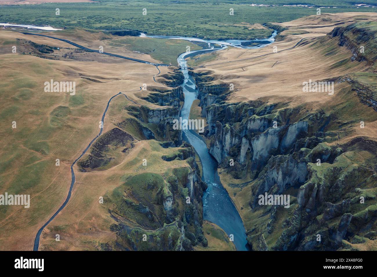 Vertical top view between hills in Iceland winding blue river, branch ...