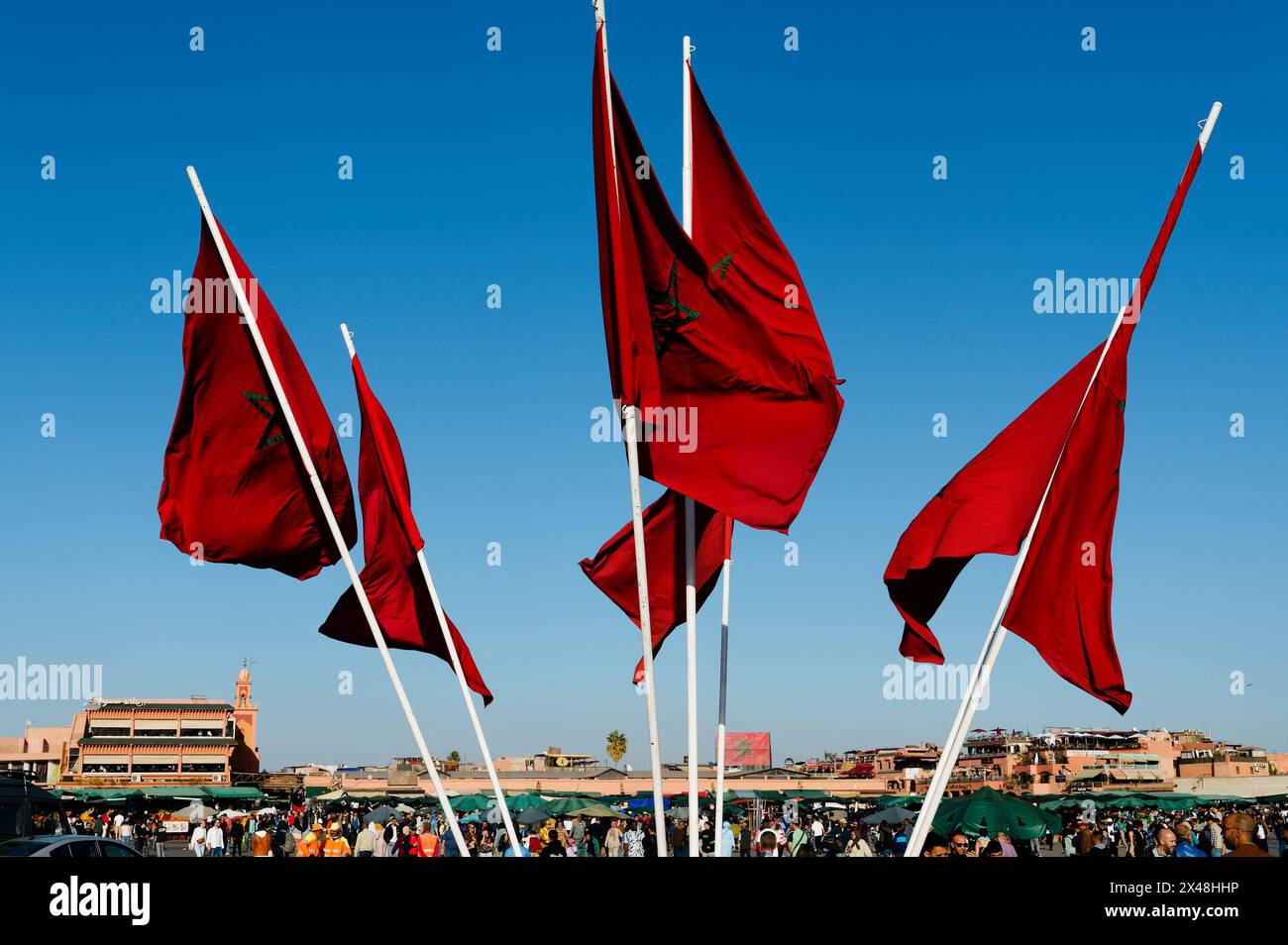 Moroccan flags waving in the blue sky over jemaa el-fnaa square ...