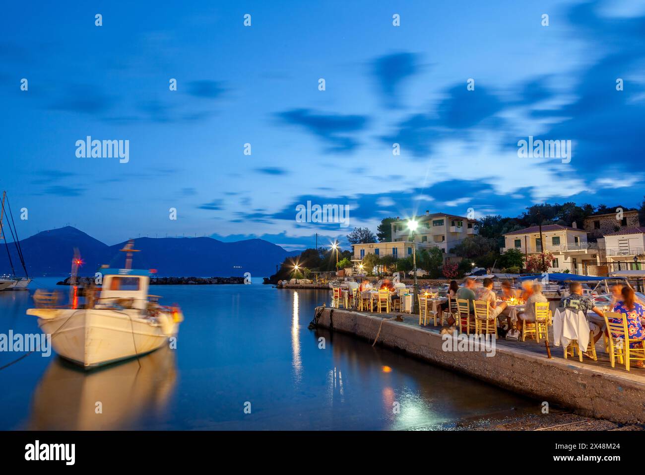 People enjoying dinner in local fish tavern, at the picturesque fishing ...