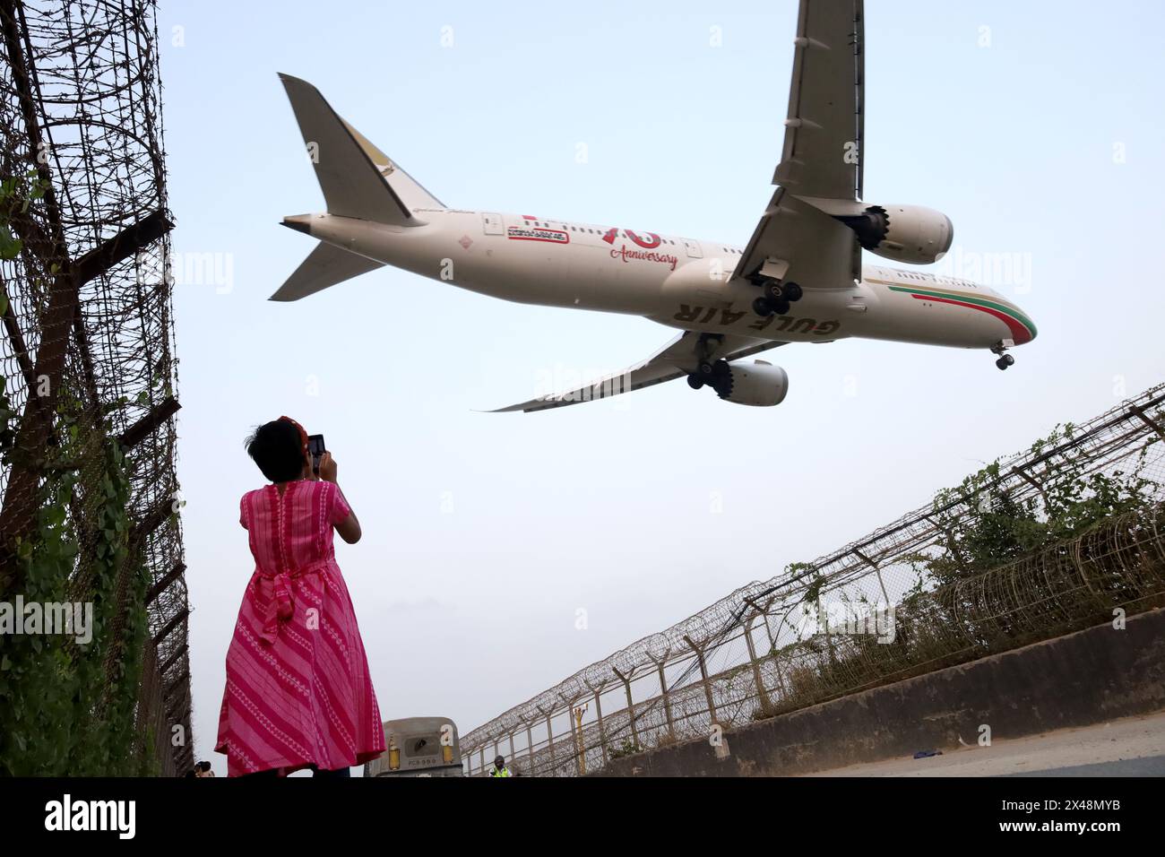 Dhaka, Dhaka, Bangladesh. 1st May, 2024. A girl captures a video of a plane landing at Dhaka ...