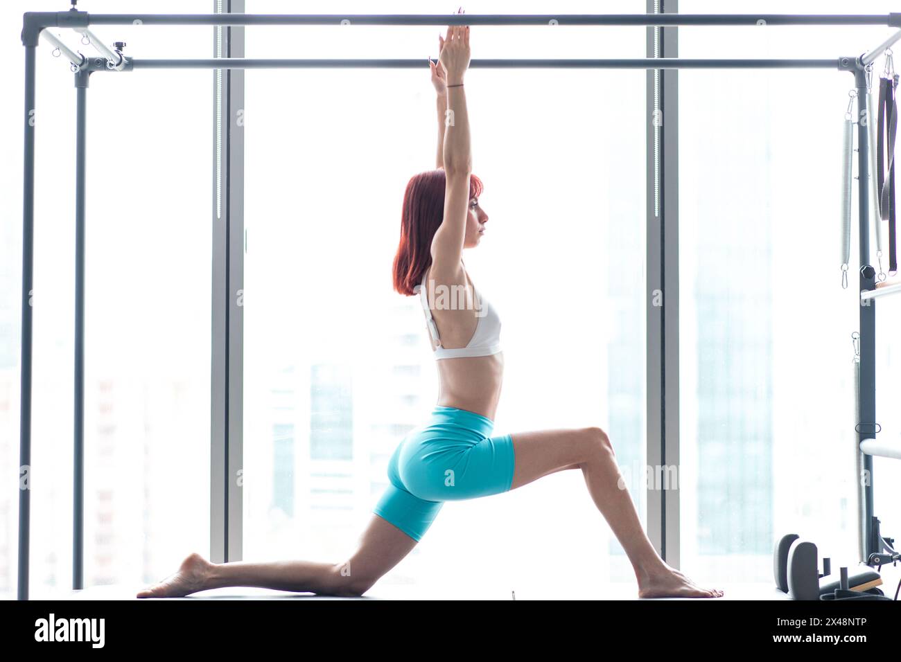 Beautiful woman performing pilates over white background with reverse ...