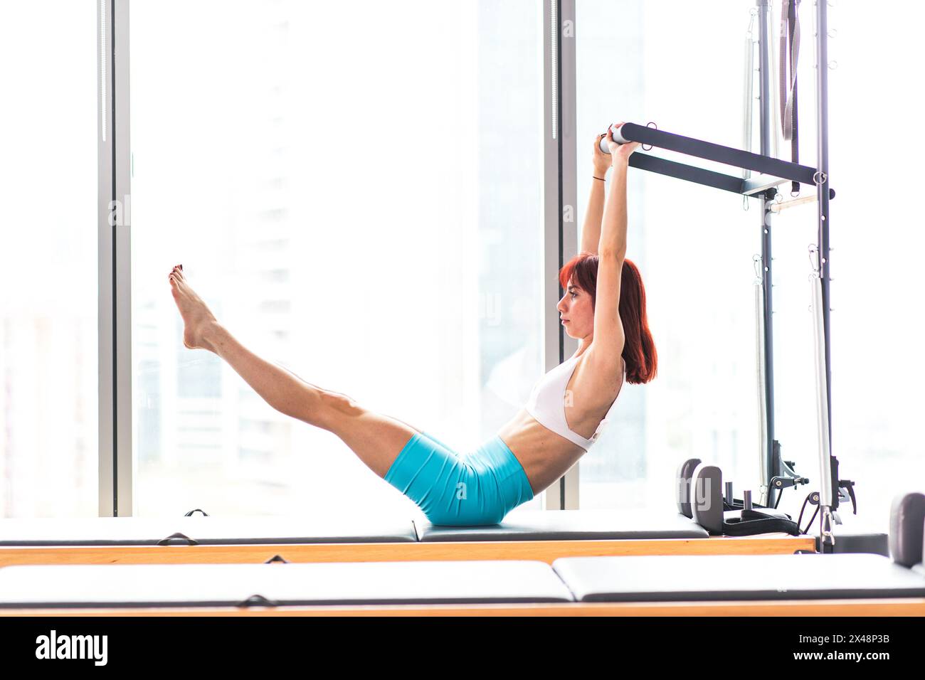 Beautiful woman performing pilates over white background with reverse ...