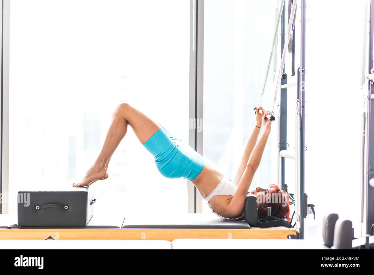 Beautiful woman performing pilates over white background with reverse ...
