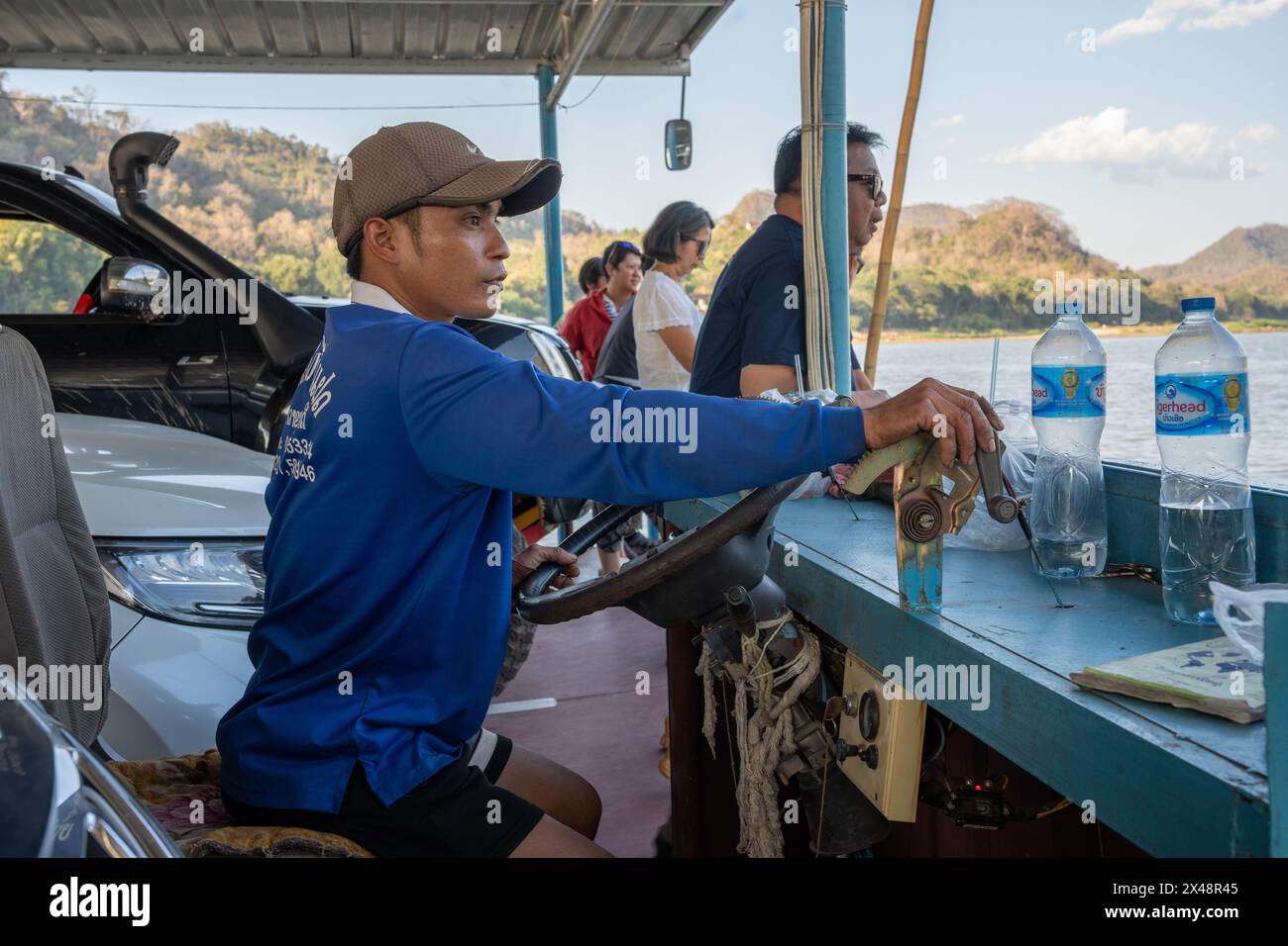 A helmsman at the control desk of a ferry on the Mekong River in Luang ...